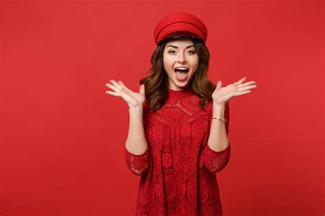 레이스 드레스 모자에 놀란 젊은 여자의 초상화는 입을 열어 스튜디오에서 밝은 붉은 벽 배경에 고립 된 손을 확산 사람들은 진심으로 감정 라이프 스타일 개념입니다 복사 공간을