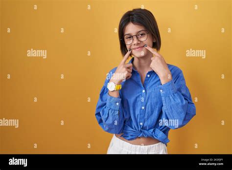 Young Girl Standing Over Yellow Background Smiling With Open Mouth Fingers Pointing And Forcing