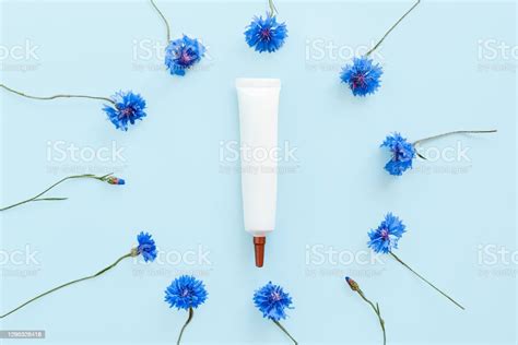 긴 노즐과 청동 나사 캡과 파란색 배경에 파란색 옥수수 꽃흰색 화장품 튜브의 모형 0명에 대한 스톡 사진 및 기타 이미지 0