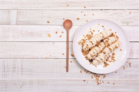 복사 공간이있는 흰색 나무 배경 위에 접시에 그라놀라와 바나나 슬라이스 건강한 천연 비타민 스낵 상단 보기 플랫 레이 0명에 대한 스톡 사진 및 기타 이미지 Istock