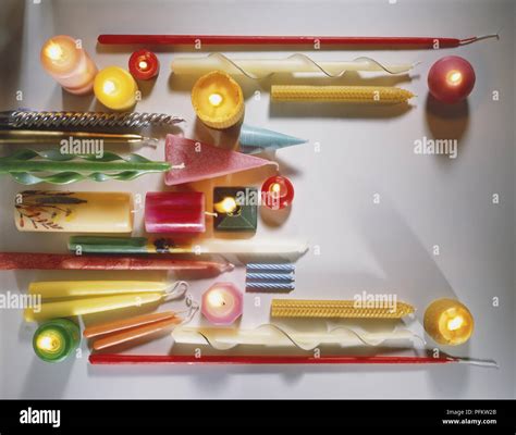 selection of candles lit and unlit of different colours and shapes