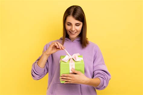 행복감을 느끼는 여자는 행복한 만족스러운 표정으로 선물 상자를 열고 선물을 기쁘게 생각합니다 노란색 배경에 대한 스톡 사진 및 기타 이미지 Istock