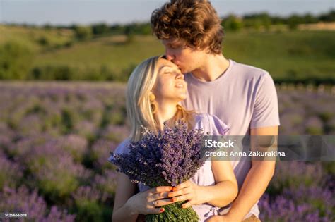 보라색 라일락 매칭 의상을 입은 커플의 초상화 라벤더 필드에서 포옹 낭만적 인 사진 세션 사랑에 빠진 남자와 여자 관계의 행복 남편과 아내 여자가 라벤더 꽃다발을 손에 들고