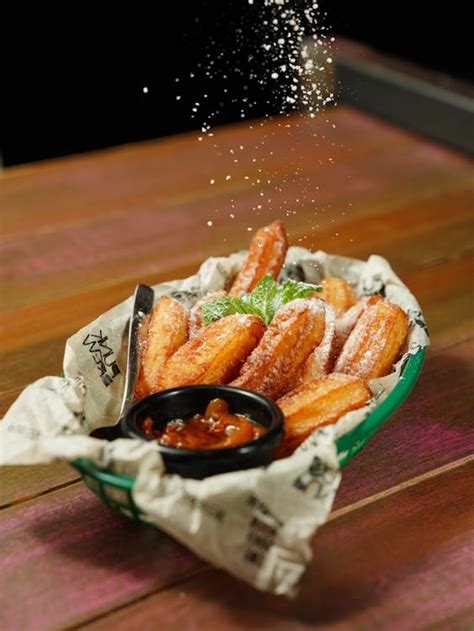 Flavorful 가루 살포 간식 시간 계피 길거리 음식 녹색 바구니 달콤한 담그다 디저트 맛있는 목조 테이블 미식가 민트 잎 밀 바삭바삭한