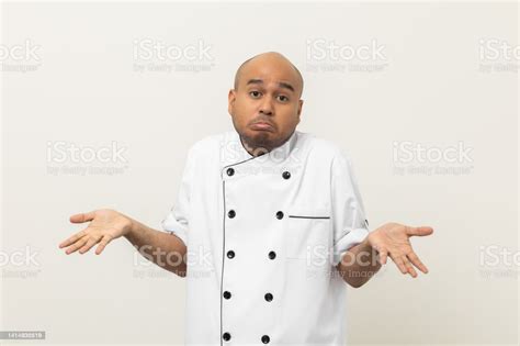 고립 된 배경에 유니폼을 입은 젊은 잘 생긴 아시아 남자 요리사를 이해하지 못하는 척하십시오 혼란스러운 요리 인도 남자 직업 요리사 또는 베이커 부엌 레스토랑과 호텔에있는