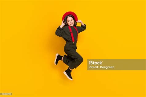 밝은 노란색 색상 배경을 통해 고립 된 재미 좋은 분위기를 가지고 점프 꽤 쾌활한 소녀의 전체 길이 몸 크기 보기 갈색에 대한