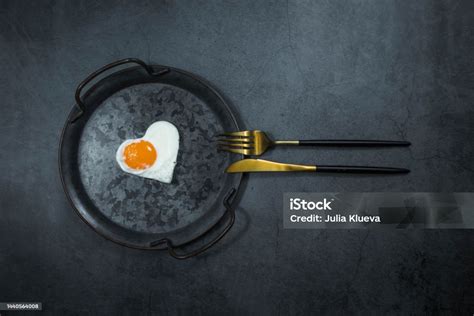 기치 빈티지 팬에 수제 계란 후라이와 어두운 배경에 세련된 칼 붙이 하트 모양의 노른자 위에서 본 모습 텍스트 공간을 복사합니다 0명에 대한 스톡 사진 및 기타 이미지