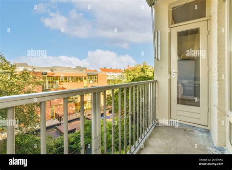 A Balcony With Trees And Buildings In The Background Taken From An Apartment Window Looking Out