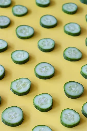 노란색 배경에 오이 슬라이스 레이어의 전체 프레임 이미지 흰색 씨앗과 녹색 피부와 흰색 살의 표시 건강한 식생활 포스터 벽지 배경 디자인 높은 전망 전경에 초점 0명에 대한