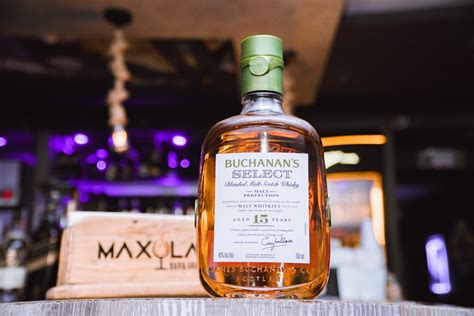 테이블에 앉아 있는 위스키 한 병 사진 Unsplash의 무료 음료 이미지