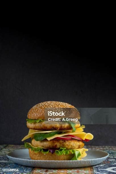 햄버거 롤빵 치즈 양상추 아루굴라 무를 곁들인 더블 치킨 커틀릿 고기 야채 빵 재료 접시에 집에서 만든 햄버거 색깔의 타일로 만든 테이블 검은색에 대한 스톡 사진 및 기타