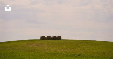 무성한 녹색 들판 위에 놓인 건초 더미 세 개 사진 Unsplash의 무료 풀 이미지