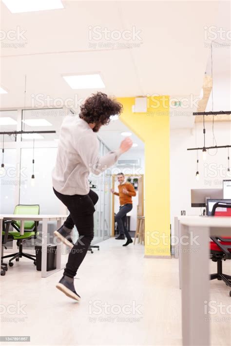 사무실에서 즐거운 시간을 보내는 두 명의 사업가 친절한 동료들이 점프하고 춤을 추며 성공을 축하합니다 20 24세에 대한 스톡 사진 및 기타 이미지 Istock