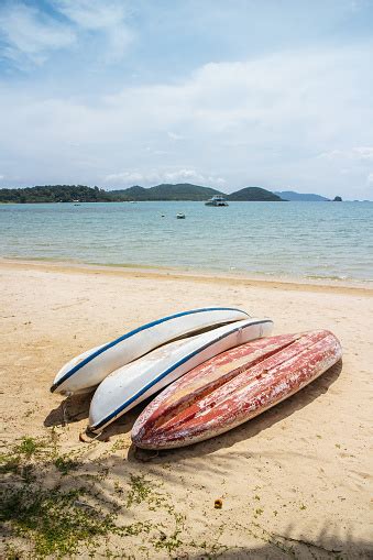 업 사이드 다운 화이트 및 레드 카약은 태국 뜨 랏의 코 막 섬에서 배경으로 맑고 푸른 하늘과 함께 바다와 산으로 해변에 정차 합니다 0명에 대한 스톡 사진 및 기타 이미지