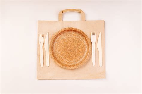 에코 공예 종이 식기 컵 패스트 푸드 용기 재활용 환경 친화적 인 개념 일회용 에코 칼 붙이 접시 숟가락 나이프 가벼운 배경에 포크 음식 배달을위한 종이 봉지를 제작하십시오