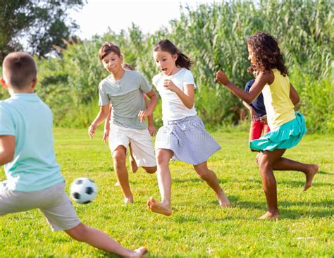 Cheerful Tween Friends Playing With Ball Outdoors In Summer Stock Image