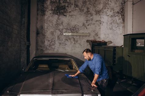 Premium Photo A Man Cleans Dust From A Retro Car In The Garage
