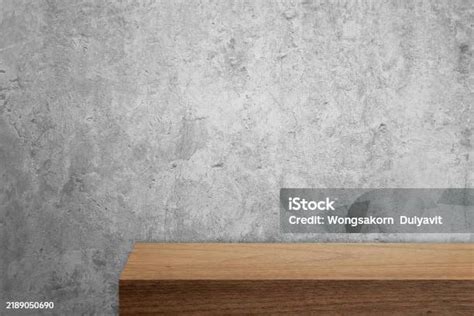 배경에 소박한 회색 치장 벽토 콘크리트 벽과 함께 제품 몽타주 디스플레이를 위한 빈 공간이 있는 갈색 나무 카운터의 가장자리