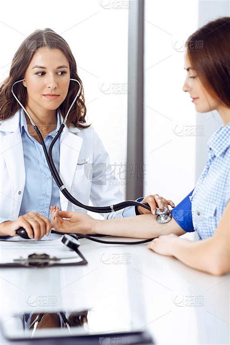 医生手里拿着听诊器正在检查她的女病人。保健、心脏病学和医学概念素材 花瓣网