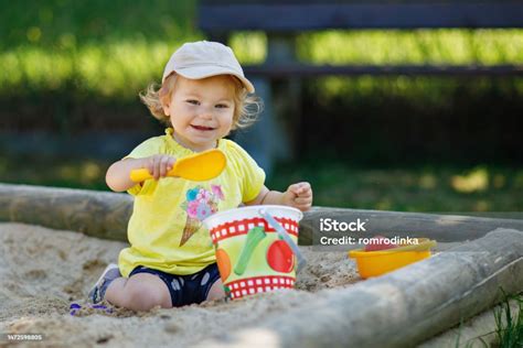 야외 놀이터에서 모래에서 노는 행복한 유아 소녀 화창한 따뜻한 여름 화창한 날에 즐거운 시간을 보내는 아기 모래 장난감과 화려한