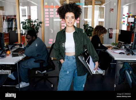 Portrait Of Confident Female Computer Programmer Standing With Hand In Pocket At Office Stock