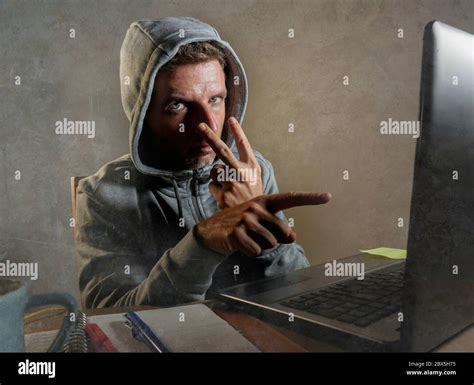 dangerous looking hacker man in hoodie hacking internet computer system