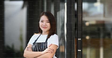 스타트업에 성공한 중소기업 소유주 여성이 팔짱을 끼고 서서 커피숍에서 카메라를 향해 웃고 있다 사진 Unsplash의 태국 이미지