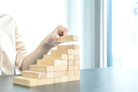 핸드 홀딩 블록 우드 게임 관리 및 전략 계획의 개념 위험 성장 비즈니스 성공 프로세스 및 팀 워크 개념에 대한 스톡 사진 및