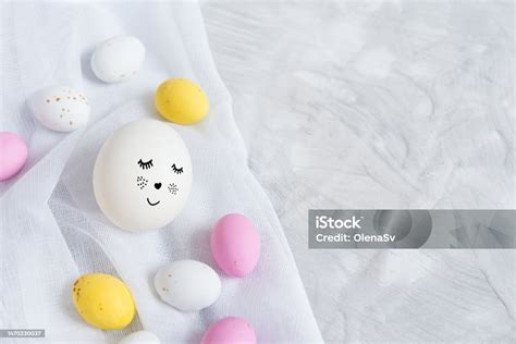 장식 행복한 부활절 개념입니다 미니멀리즘 하이킹이 있는 계란 밝은 회색 배경에 흰색 천에 초콜릿 캔디 계란 계란에 귀여운 재미있는 그림 공간을 복사합니다 0명에 대한 스톡