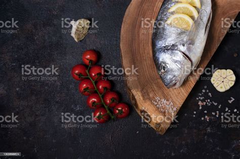 어두운 배경에 나무 보드에 신선한 도라도 물고기 체리 토마토 올리브 오일 칠리 마늘 소금 후추로 요리 지중해 식단의 요리 건강한 생활방식에 대한 스톡 사진 및 기타 이미지