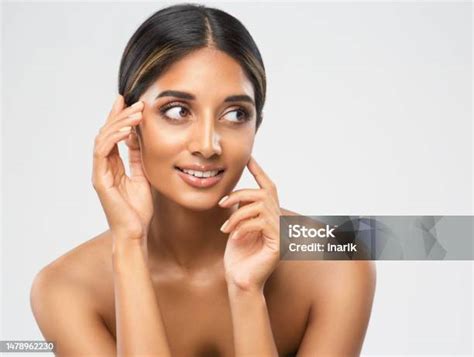 ผลิตภัณฑ์ดูแลผิวหน้าความงาม ภาพผู้หญิงสวยมองด้านข้างมากกว่าสีขาว สาวอินเดียยิ้มสัมผัสแ ภาพสต็อก