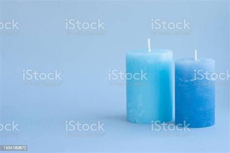 파란색 배경에 인테리어 디자인을위한 두 개의 파란색 왁스 캔들 세트 미니멀하고 아름다운 액세서리 추운 겨울 선물과 집 카페