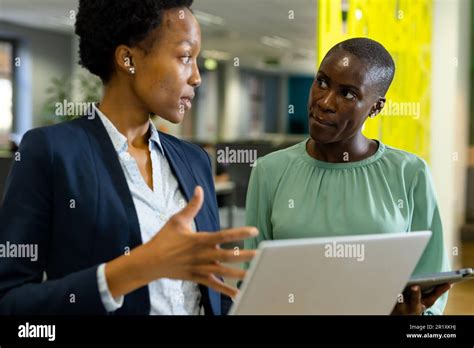 African American Coworkers Analyzing Progress Reports Over Digital Tablet And Laptop On Desk