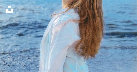 낮에 바다 근처에 서 있는 흰 셔츠를 입은 여자 사진 Unsplash의 무료 초상 이미지