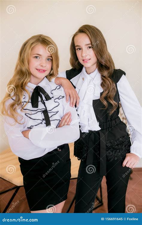 Two Cute Girls Schoolgirls With Long Curly Hair In Fashionable School