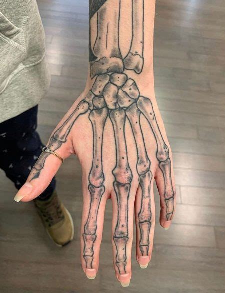 Skeleton Tattoo On Hand With Pen Artistic Design And Meaning
