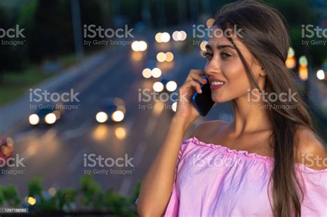 젊은 아름다운 소녀 사용 그녀의 스마트 폰 위에 바쁜 도시 거리 에 밤 Brand Name Online Messaging Platform에 대한 스톡 사진 및 기타 이미지