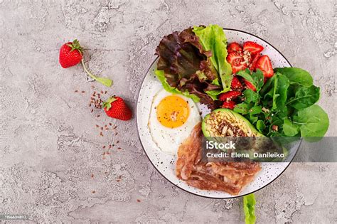 케토 다이어트 음식과 접시 계란 베이컨 아보카도 아루굴라 딸기 튀김 케토 아침 식사 맨 위 보기 개념에 대한 스톡 사진 및 기타 이미지 Istock