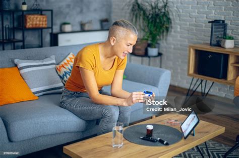 맥박 산소 측정기로 산소 농도를 측정하고 화상 통화로 의사와 대화하는 여성 40 49세에 대한 스톡 사진 및 기타 이미지 40 49세 건강 검진 건강 진단 Istock