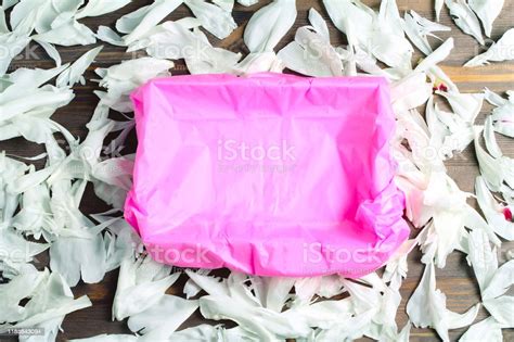 나무 배경에 흰색 꽃잎 분홍색 포장지가 있는 상자를 엽니다 크리에이티브 레이아웃 상단에서 보기 0명에 대한 스톡 사진 및 기타 이미지 Istock