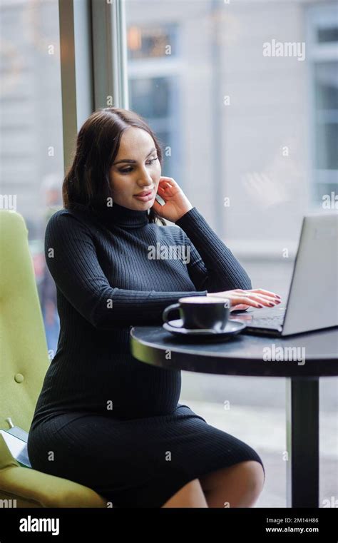 A Pregnant Business Woman Sits At A Table In The Office Works At A