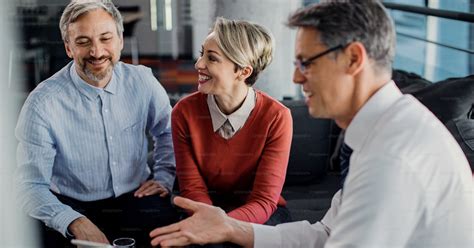 행복한 중년 부부와 그들의 재정 고문은 사무실에서 회의하는 동안 터치패드로 계획을 읽습니다 사진 Unsplash의 재정 고문 이미지