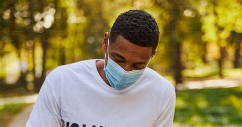 흰색 티셔츠와 파란색 장갑을 끼고 은퇴한 여성을 돕고 휠체어를 도로에서 굴리는 돌보는 자원 봉사자 사진 Unsplash의 코로나 바이러스 이미지