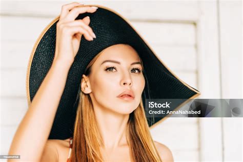 큰 모자를 쓰고 흰색 배경에 포즈를 취하는 아름다운 젊은 여성의 야외 패션 초상화 거리에 대한 스톡 사진 및 기타 이미지