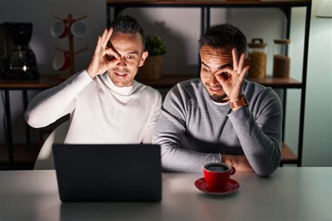 Homosexual Couple Using Computer Laptop Doing Ok Gesture With Hand Smiling Eye Looking Through