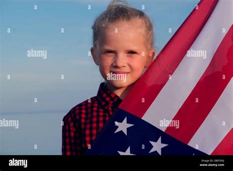 Blonde Girl Waving National Usa Flag Outdoors Over Blue Sky At Summer American Flag Country