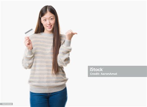 신용 카드 고 행복 얼굴 미소와 측면까지 손가락으로 보여주는 격리 된 배경 위에 젊은 중국 여자 가리키기에 대한 스톡 사진 및 기타 이미지 Istock