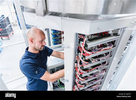 Man Using Voltmeter In Modern Factory Stock Photo Alamy
