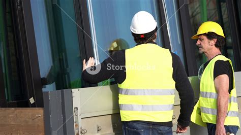Construction Workers Checking Glass Windows Before Siting And