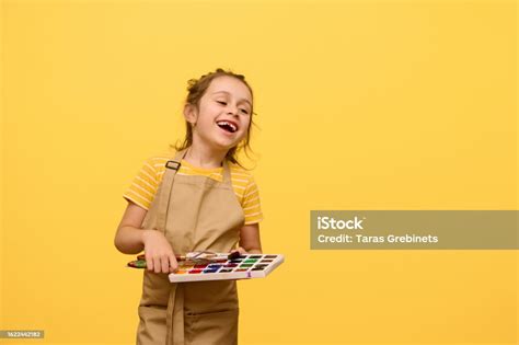 백인 소녀는 웃고 미술 수업 중에 긍정적인 감정을 표현하고 수채화 물감과 붓을 들고 있다 6 7 살에 대한 스톡 사진 및 기타 이미지 Istock